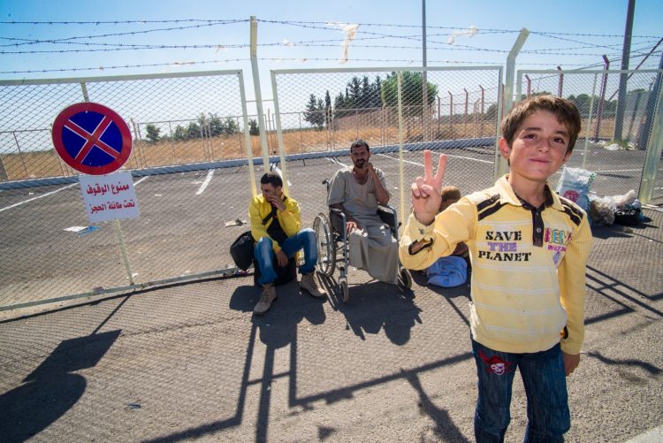 Syrian refugee boy flashes peace sign along border in Turkey | The Record